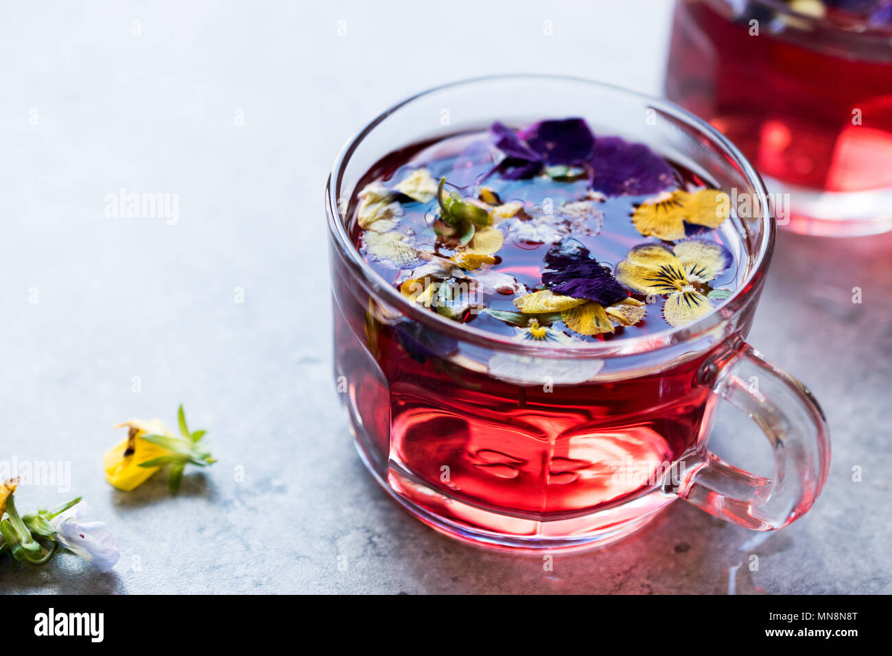 Red Herbal Tea with Edible Flowers. Organic Beverage Stock Photo - Alamy