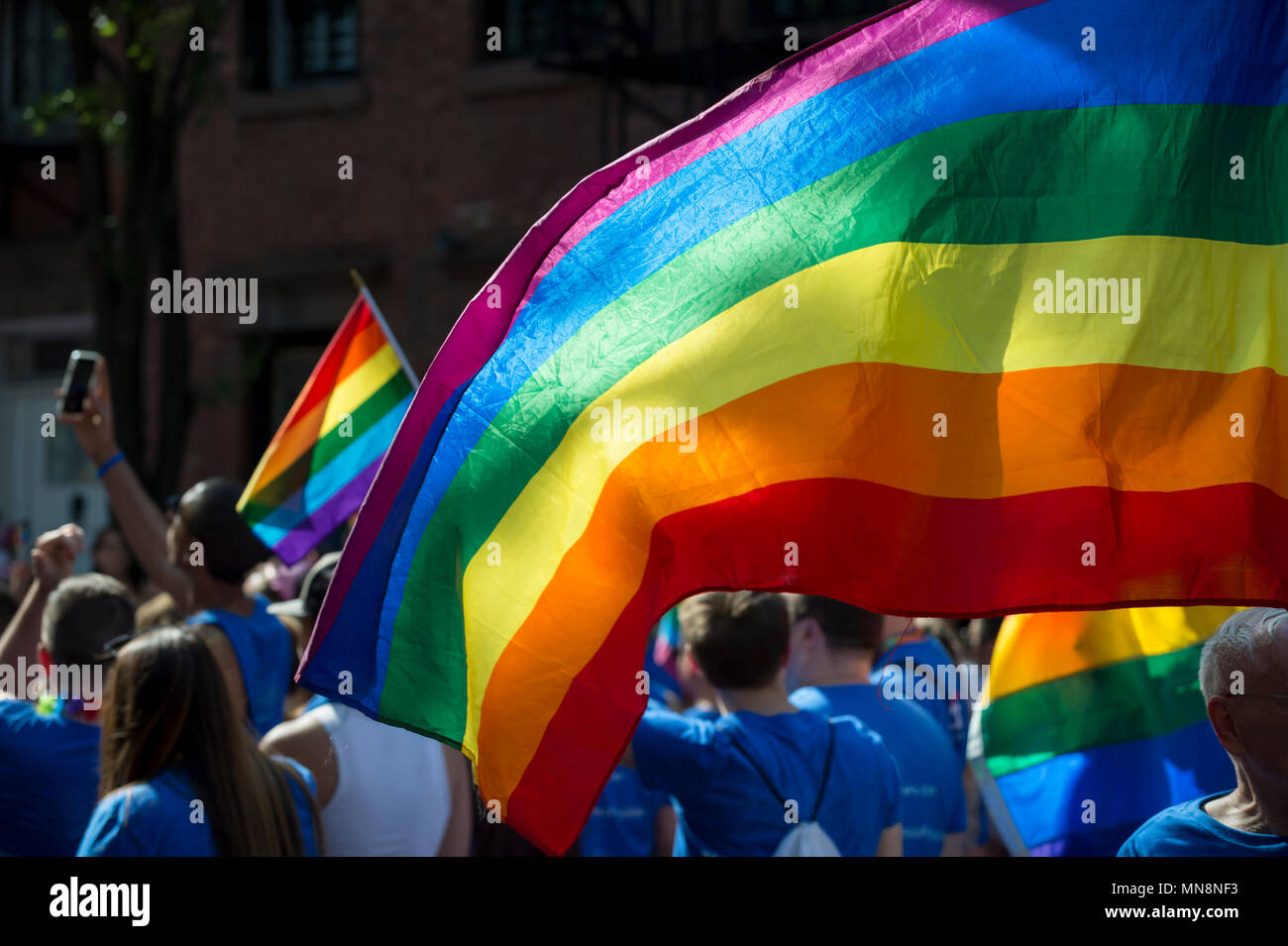 NEW YORK CITY - JUNE 25, 2017: Participants wave rainbow flags in the ...