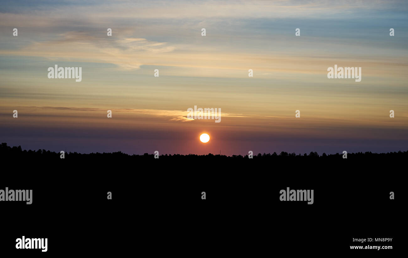 Colorful sky and rising sun still low on the horizon Stock Photo - Alamy