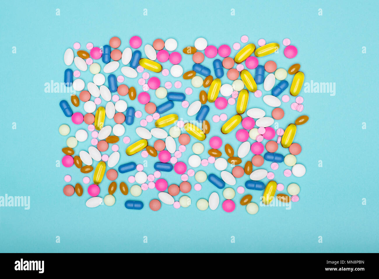 Assortment of various colourful pills on pastel coloured background ...