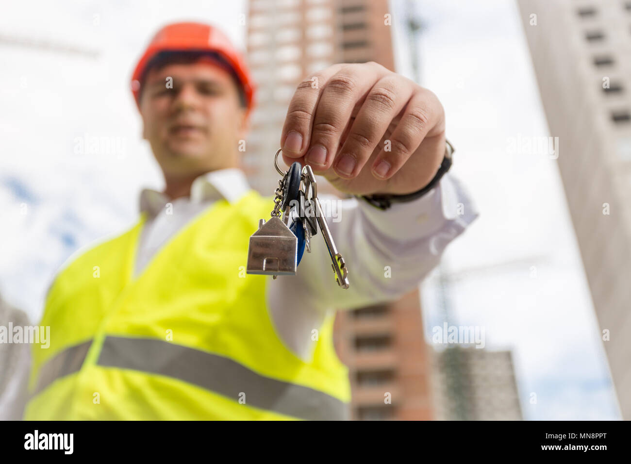 Closeup image of male businessman standing on building site and showing ...