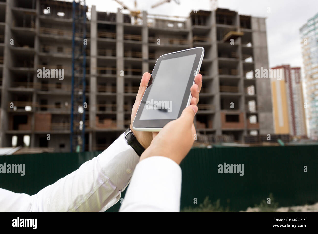 Closeup image of young man in white shirt holding digital tablet ...