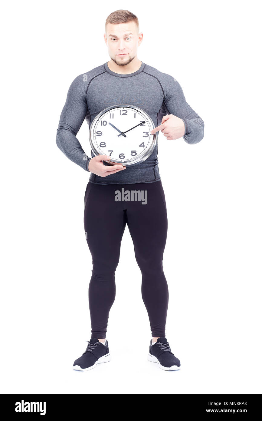 Full-length portrait of fit athlete holding wall clock on white ...
