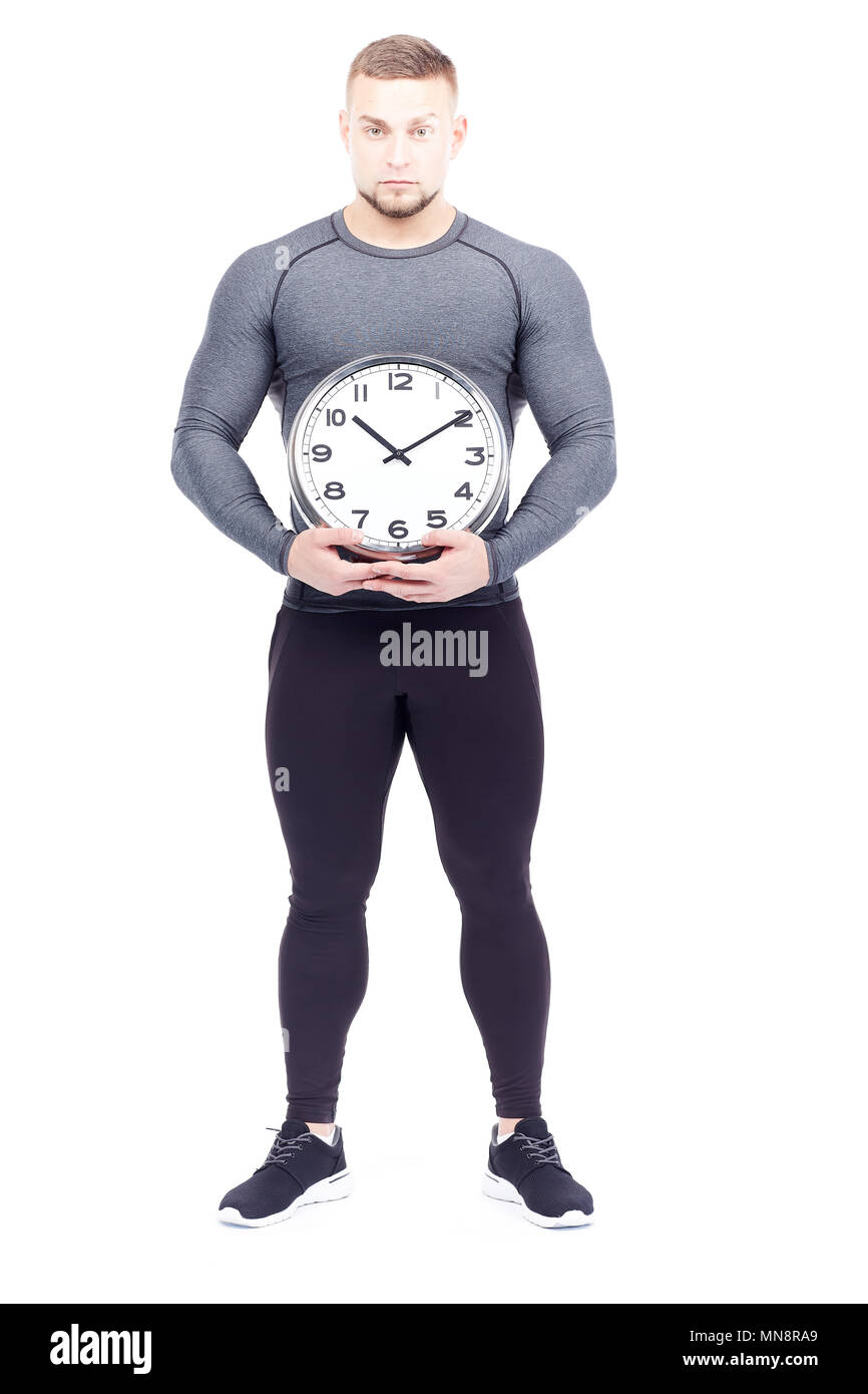 Full-length portrait of fit athlete holding wall clock on white ...