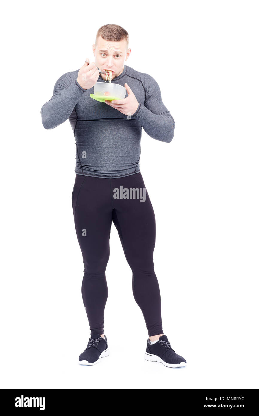 Portrait of male athlete eating spaghetti from plastic lunch box Stock ...