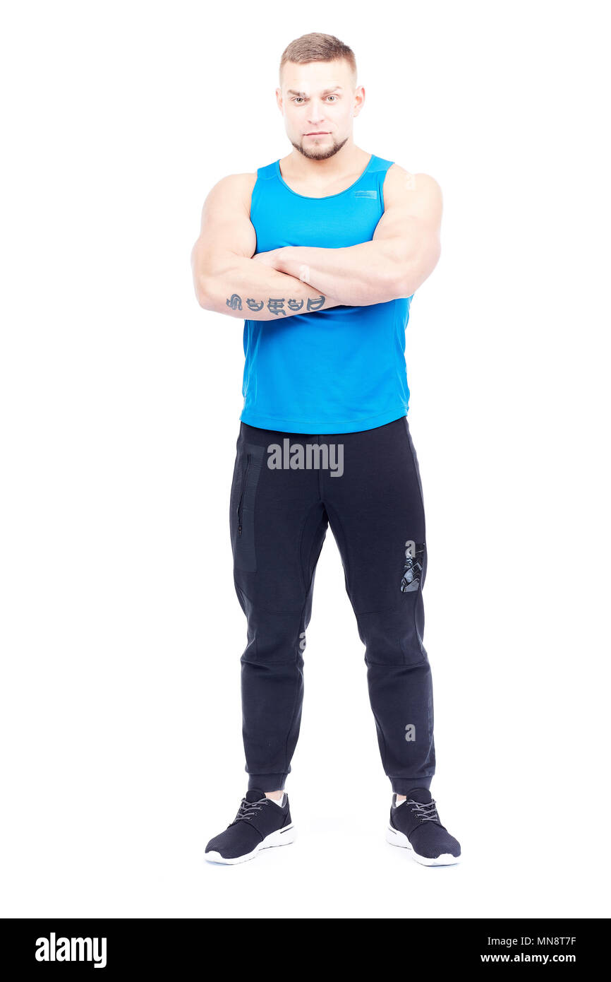 Portrait of strong athletic man in sports clothes posing on white ...