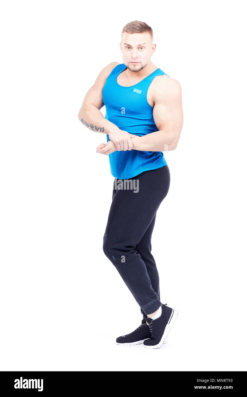 Portrait of strong athletic man in sports clothes posing on white ...