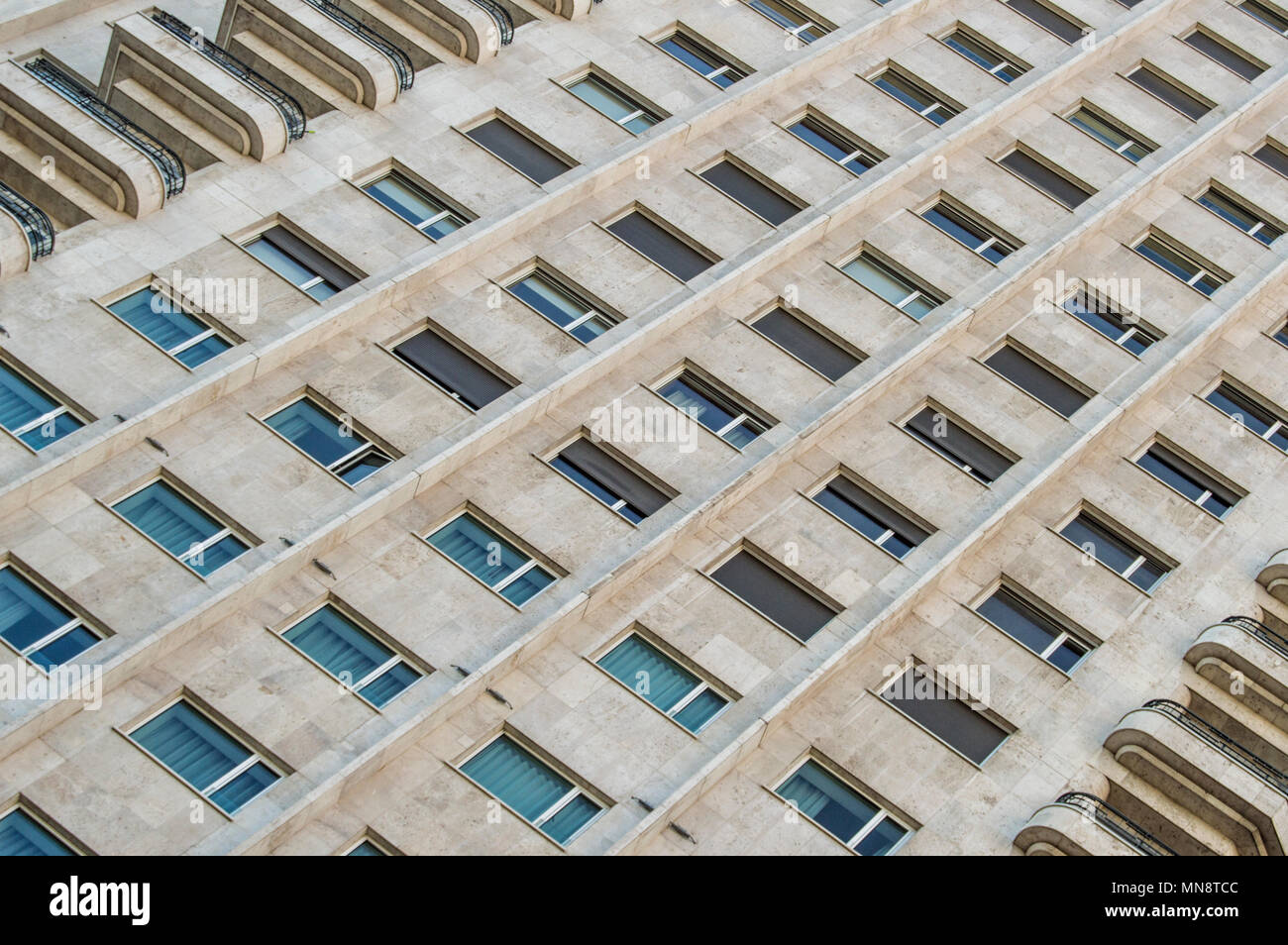 diagonal image of a white facade with windows in a building of Madrid ...