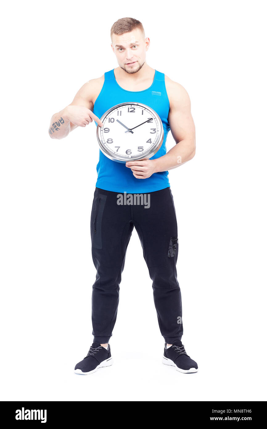 Full-length portrait of fit athlete holding wall clock on white ...