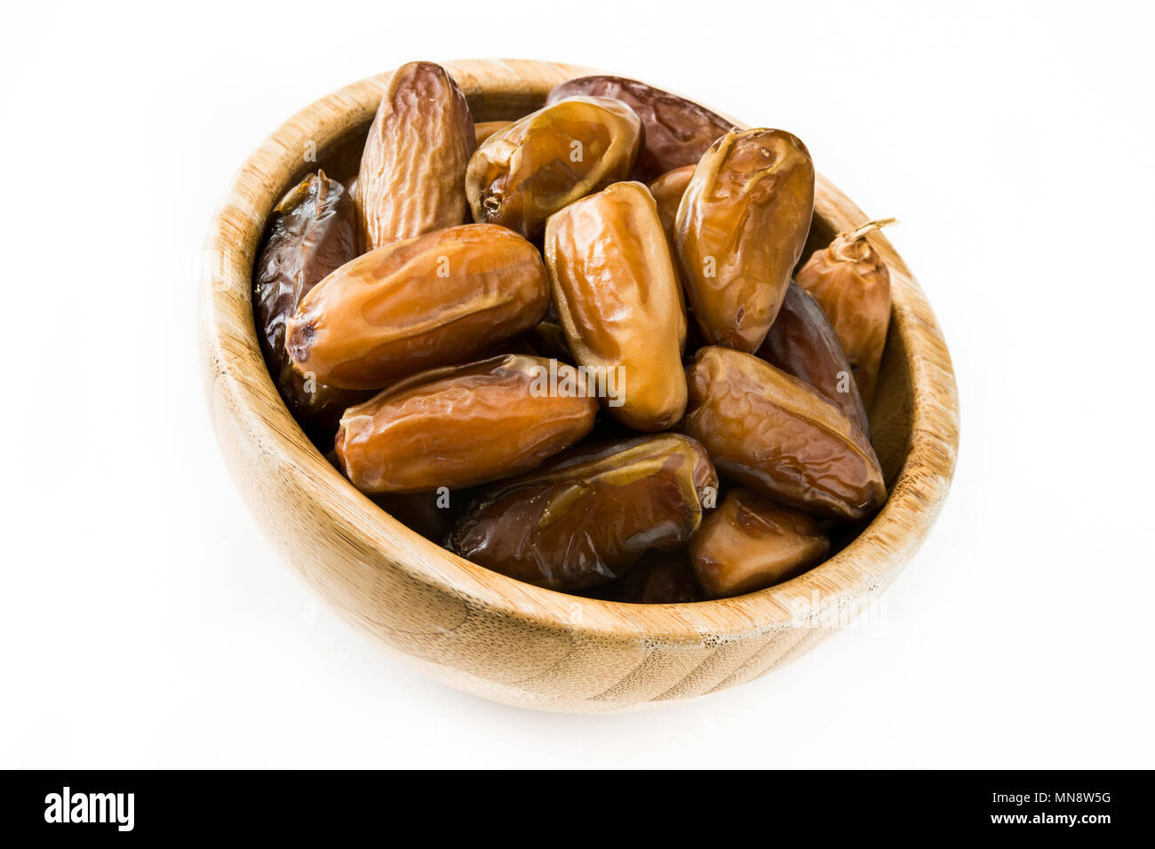Dates food in wooden bowl isolated on white background Stock Photo - Alamy