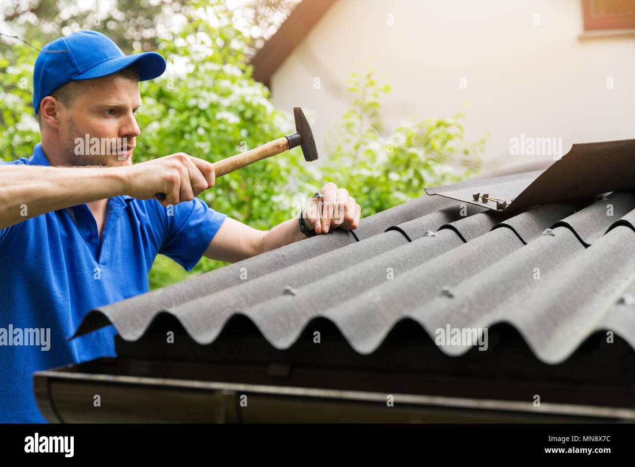 roofer installing bitumen roof sheets Stock Photo - Alamy