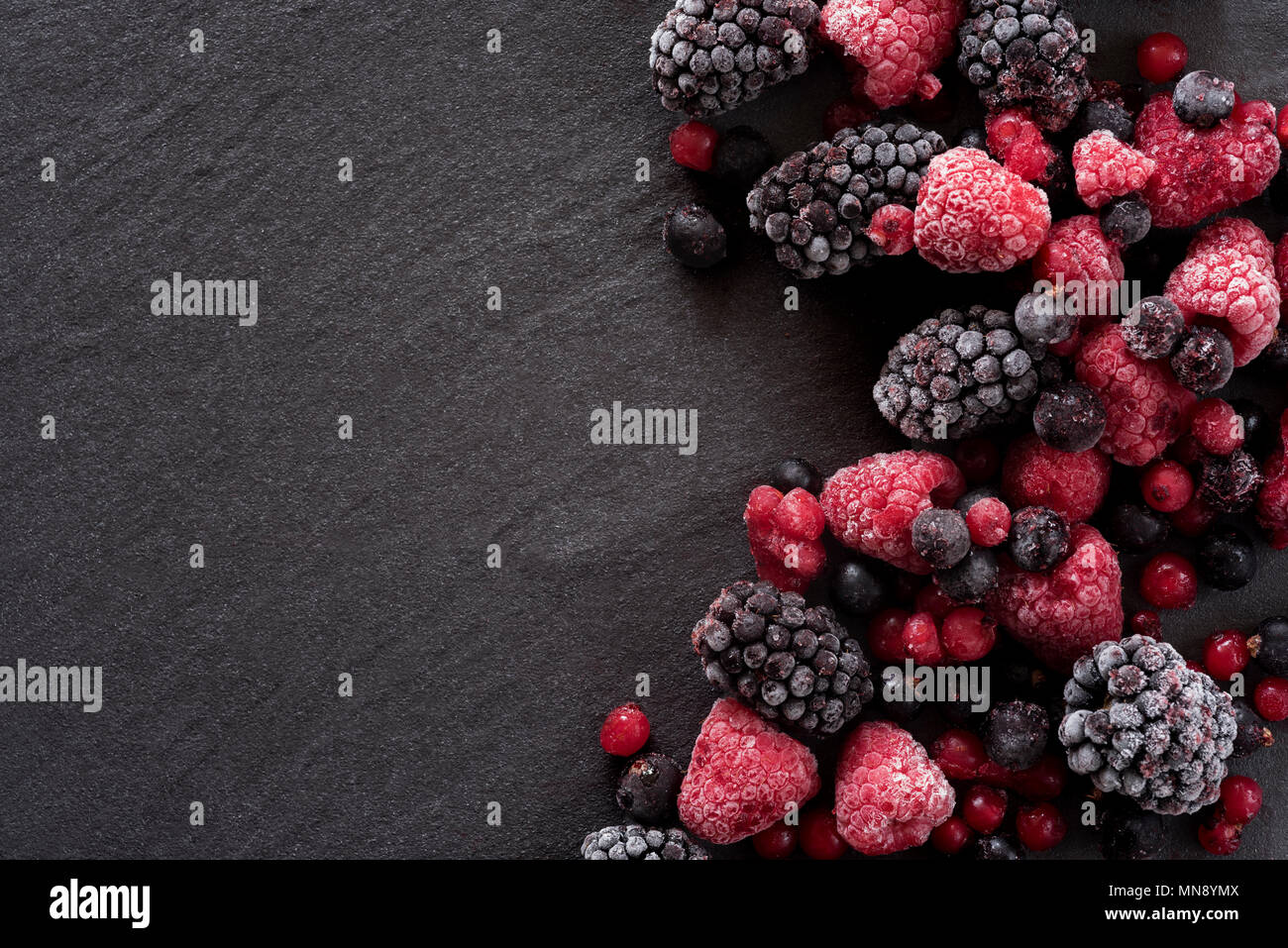 Frozen summer berries on a slate background, blackberry raspberry, red ...