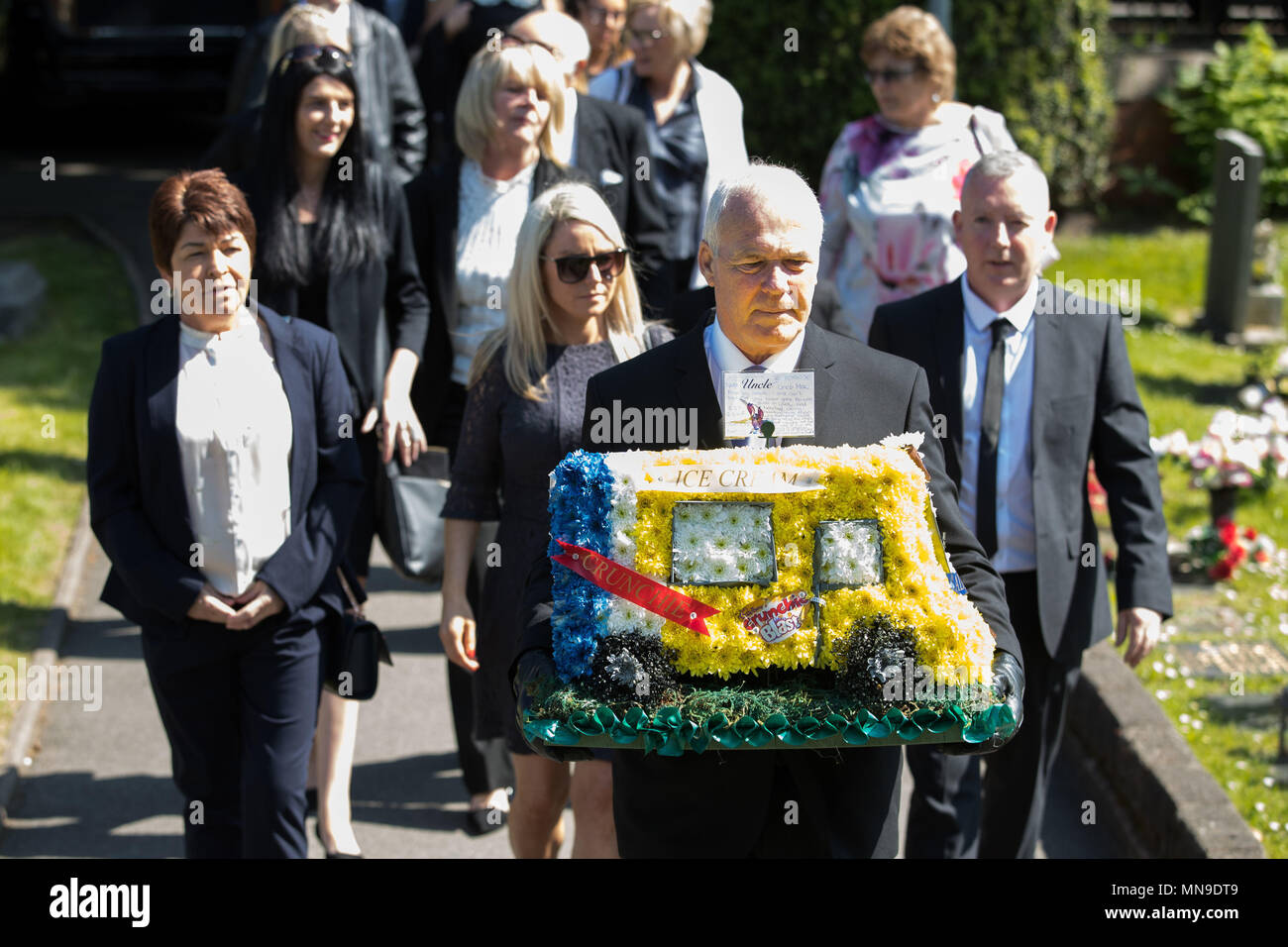 An ice cream van floral tribute is carried by mourners as they arrive ...