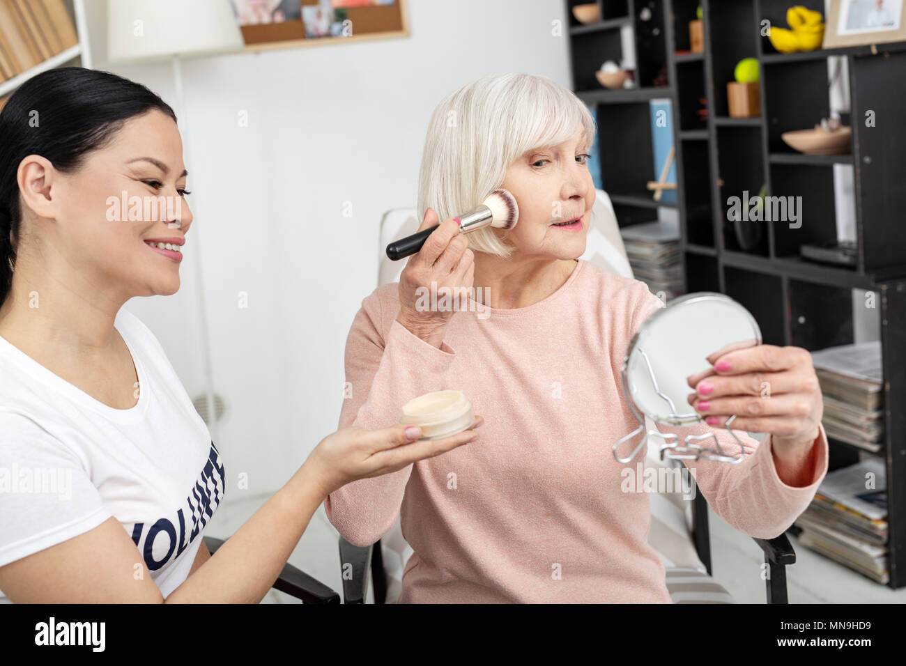 Mature woman applying face powder hi-res stock photography and images ...