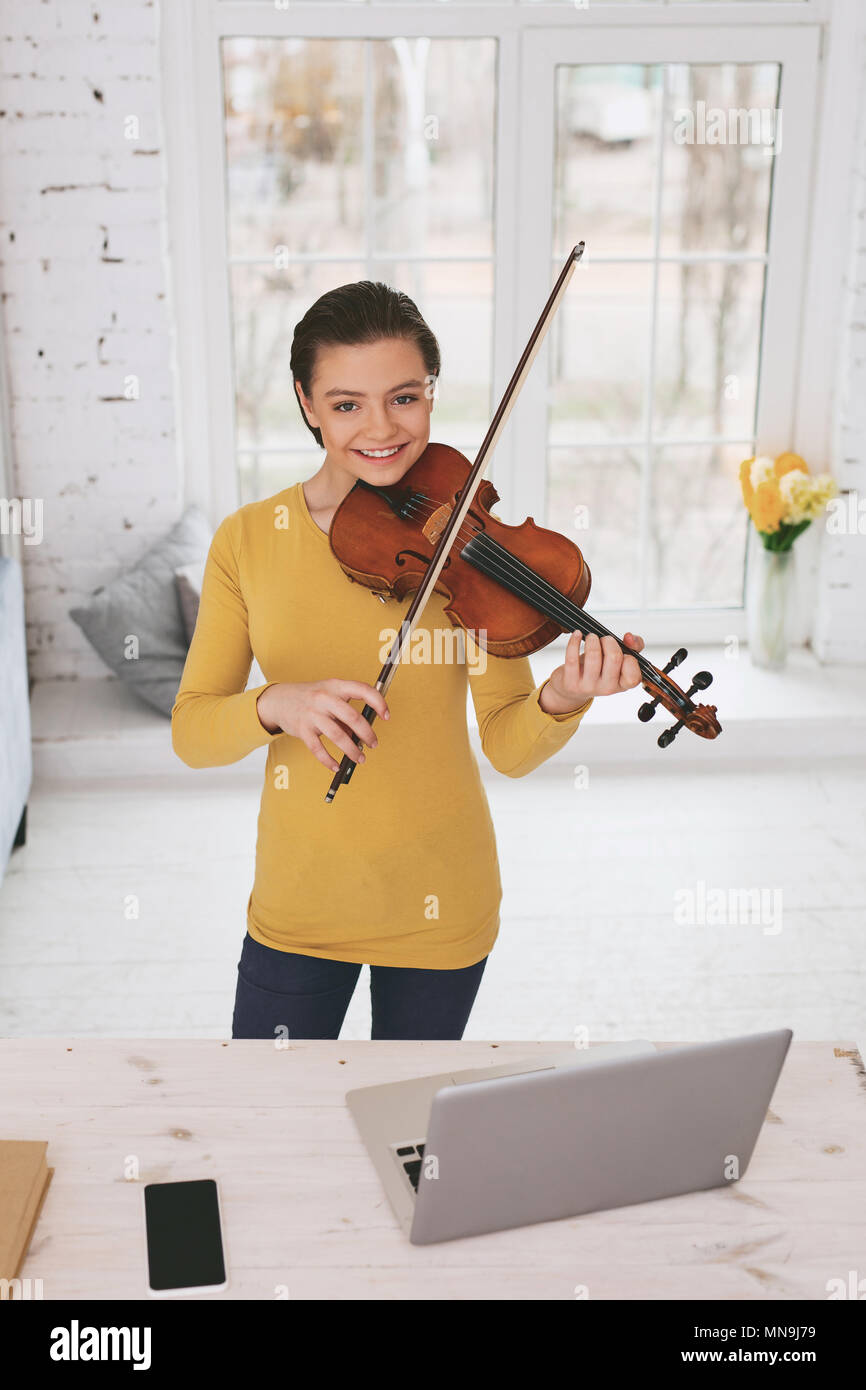 Joyful schoolgirl learning classical melody Stock Photo - Alamy