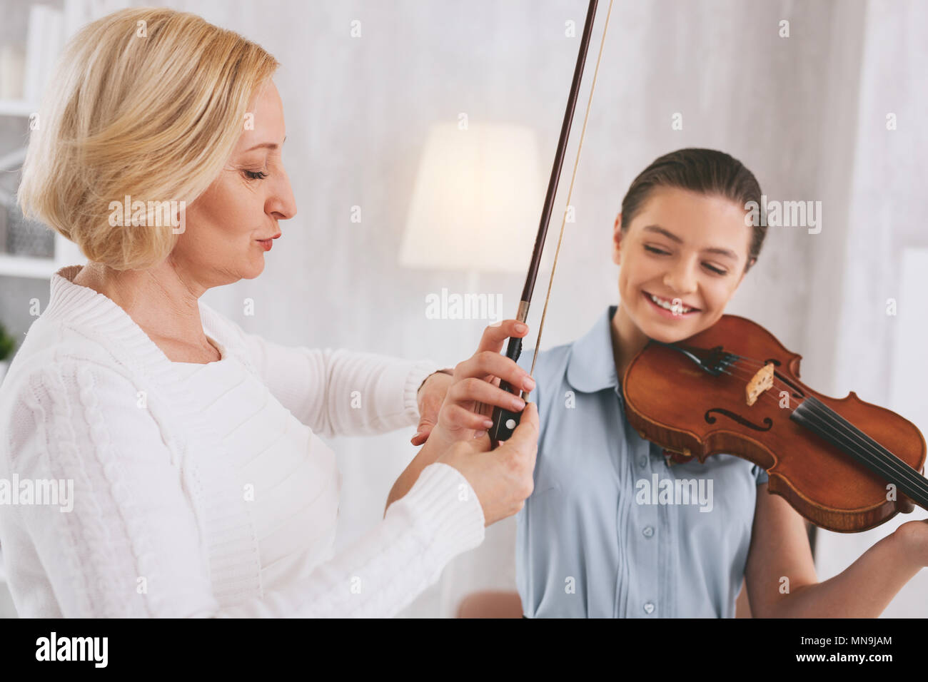 Serious tutor demonstrating the way of playing Stock Photo - Alamy