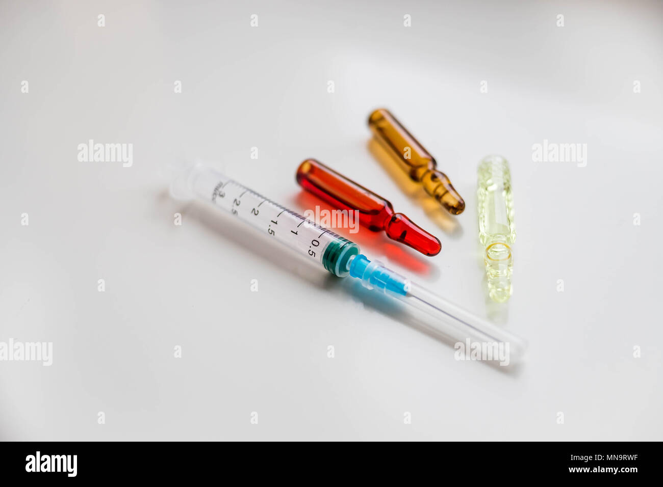 Medical colorful vials for injection syringe and red heart on a white ...