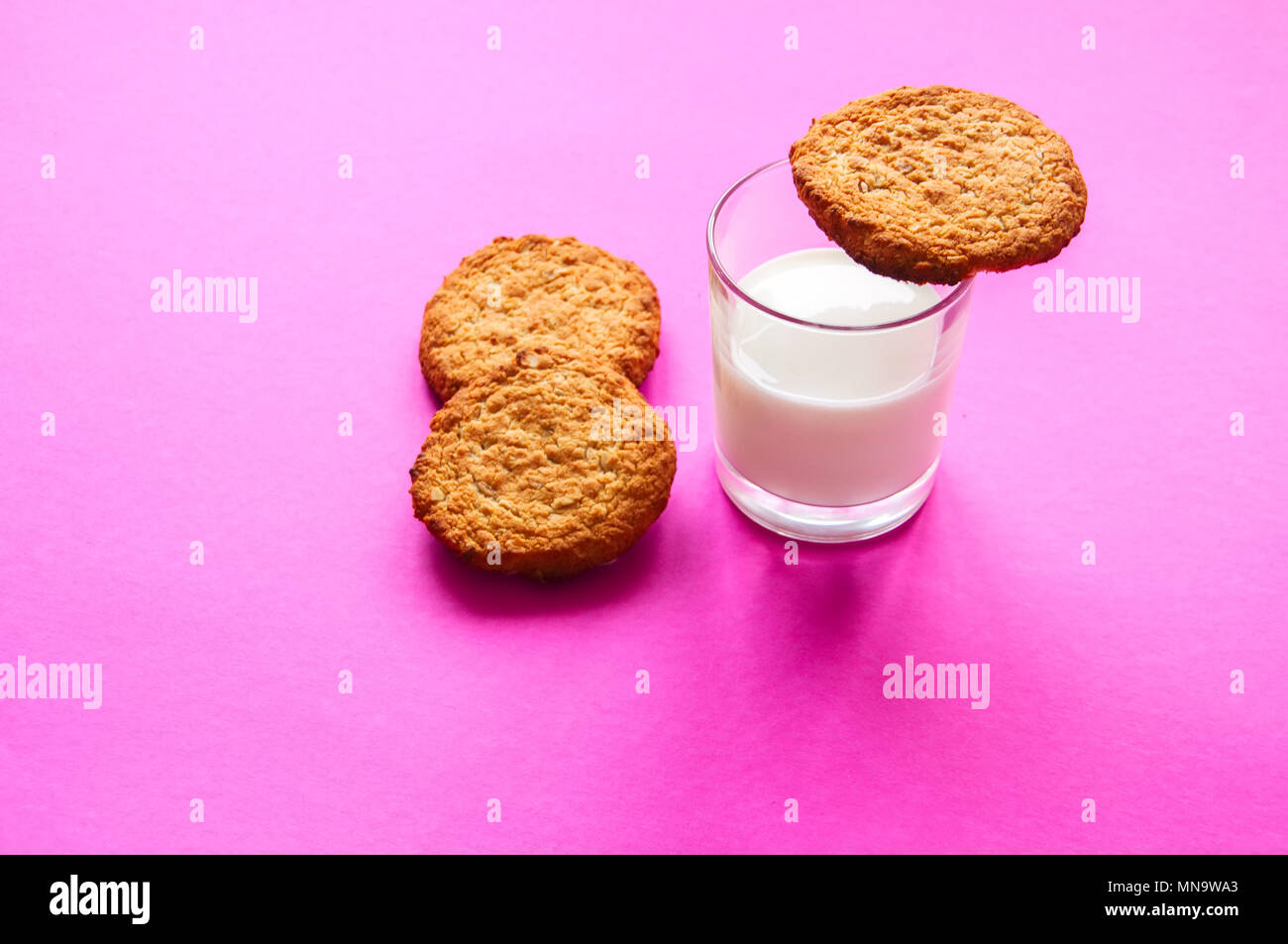 Cookies with a glass of milk on a magenta background Stock Photo - Alamy
