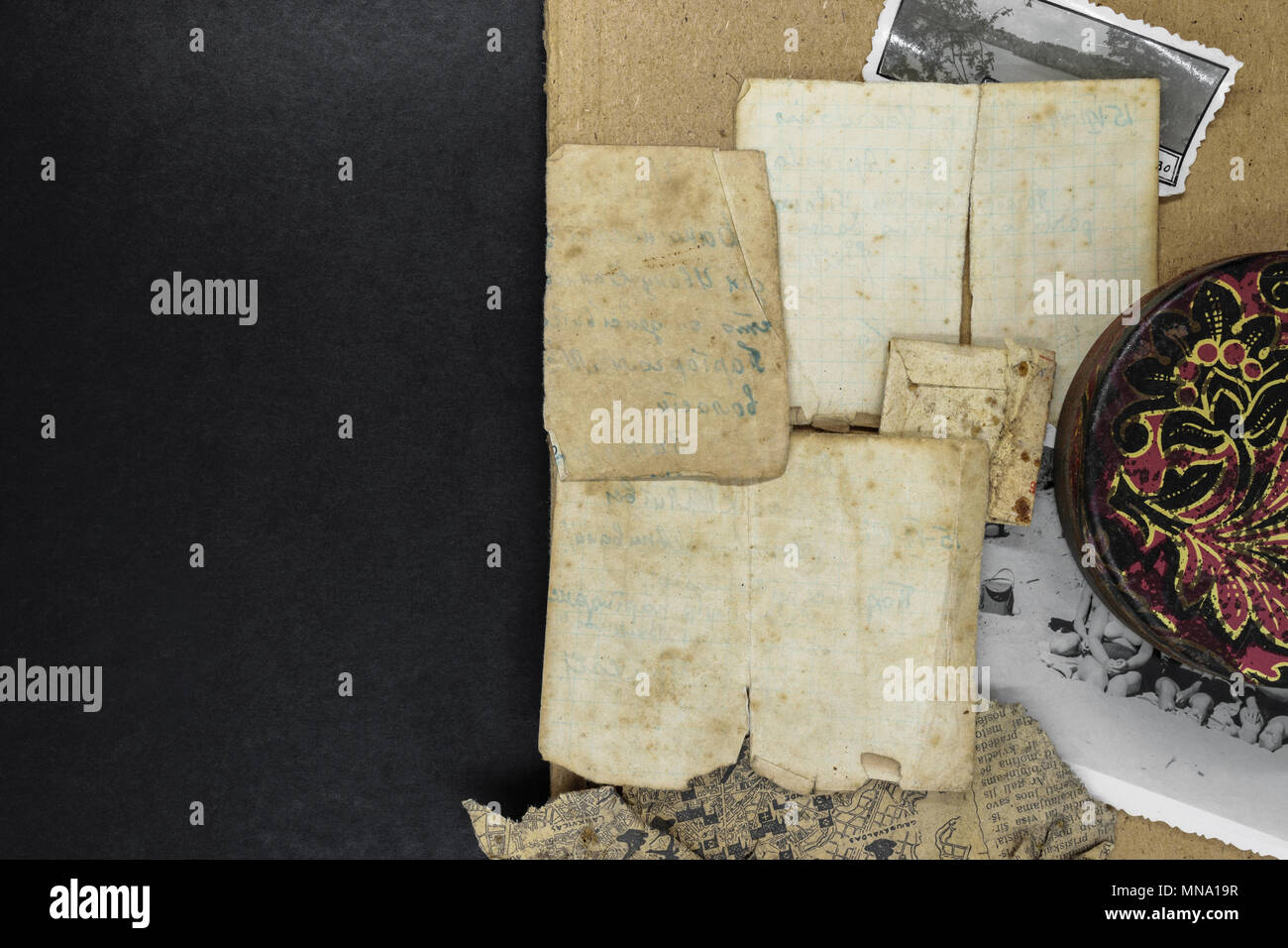 Mix of old and aged document, photo and metal box on black background ...