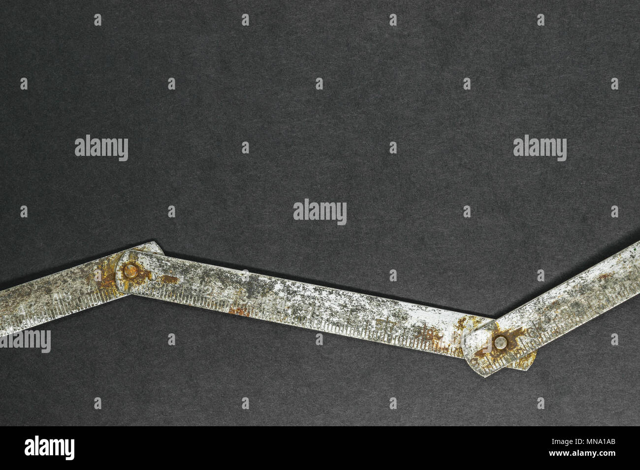 Old, rusty metal ruler on black background surface with free space ...