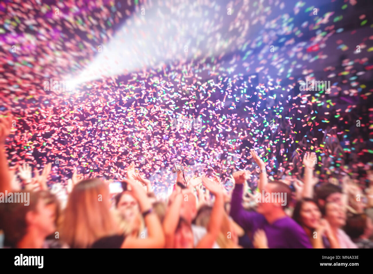 A crowded concert hall with scene stage lights, rock show performance ...