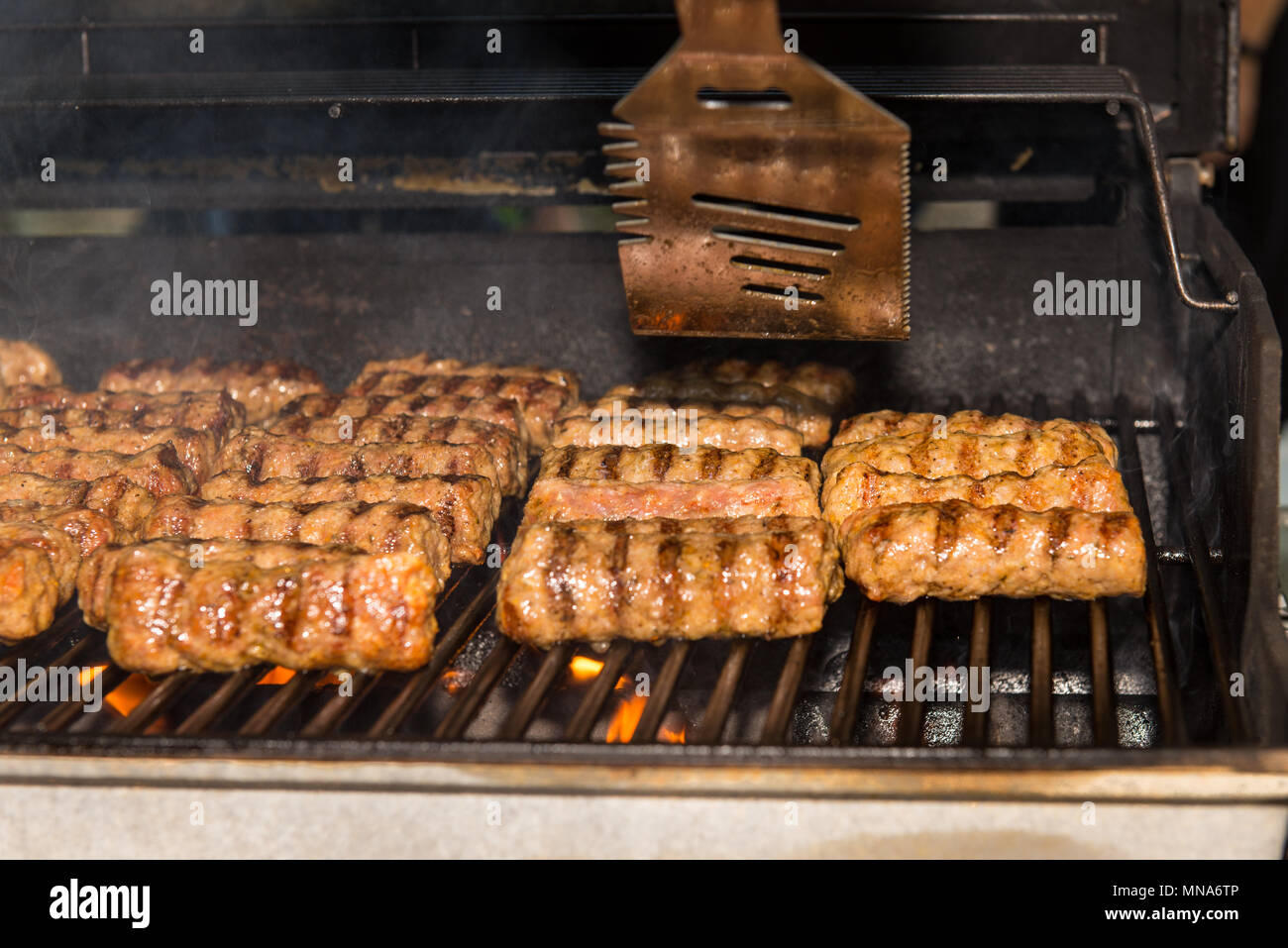 Meat rolls (mititei, mici) on the grill which is a traditional Balcanic ...