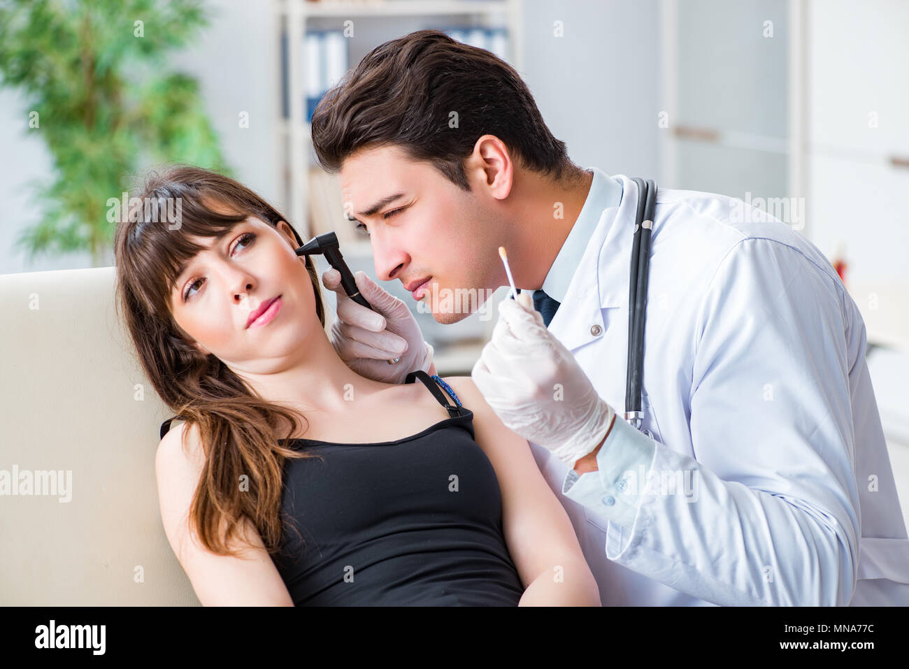 Doctor checking patients ear during medical examination Stock Photo - Alamy