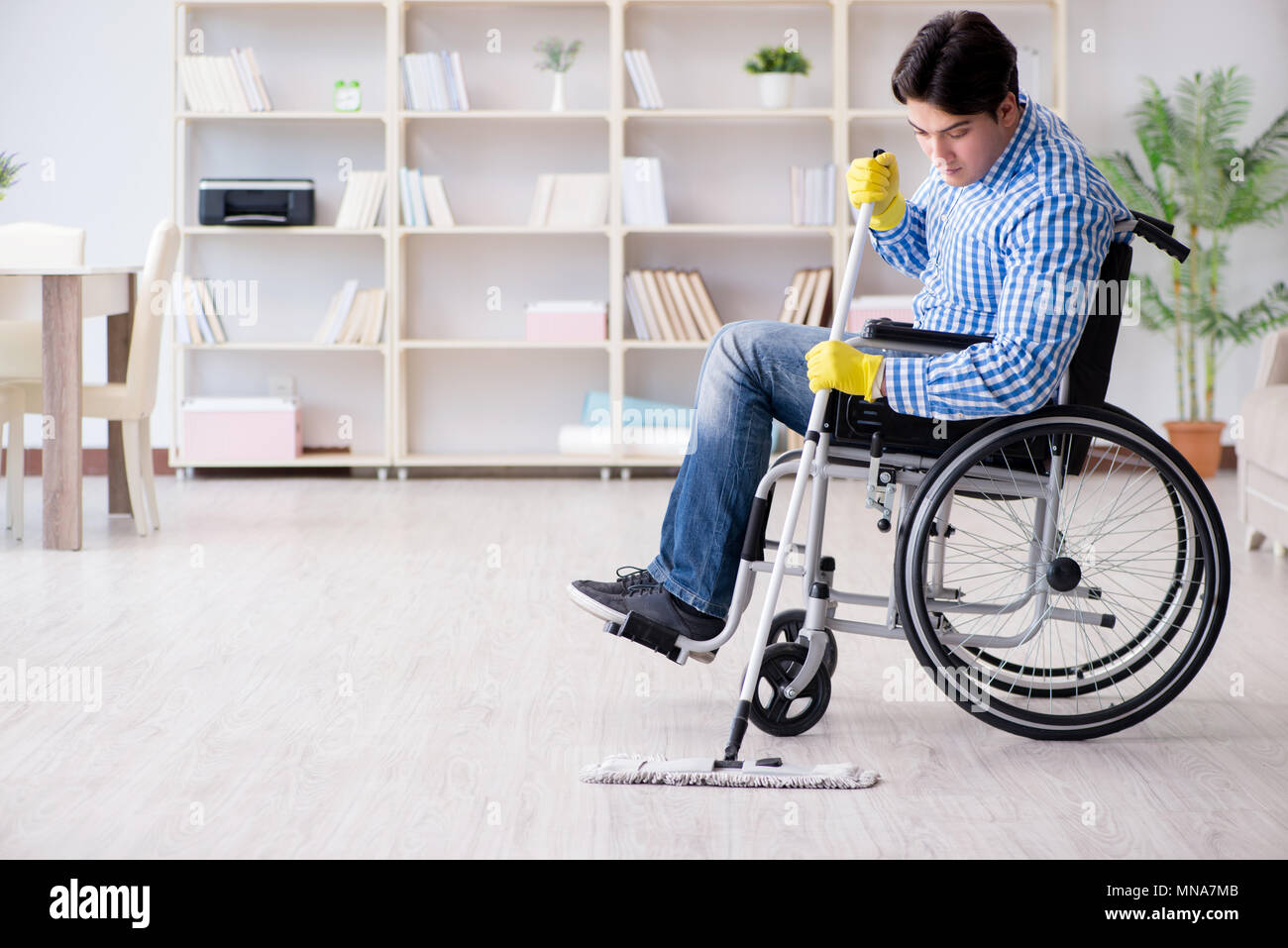 Disabled man on wheelchair cleaning home Stock Photo - Alamy