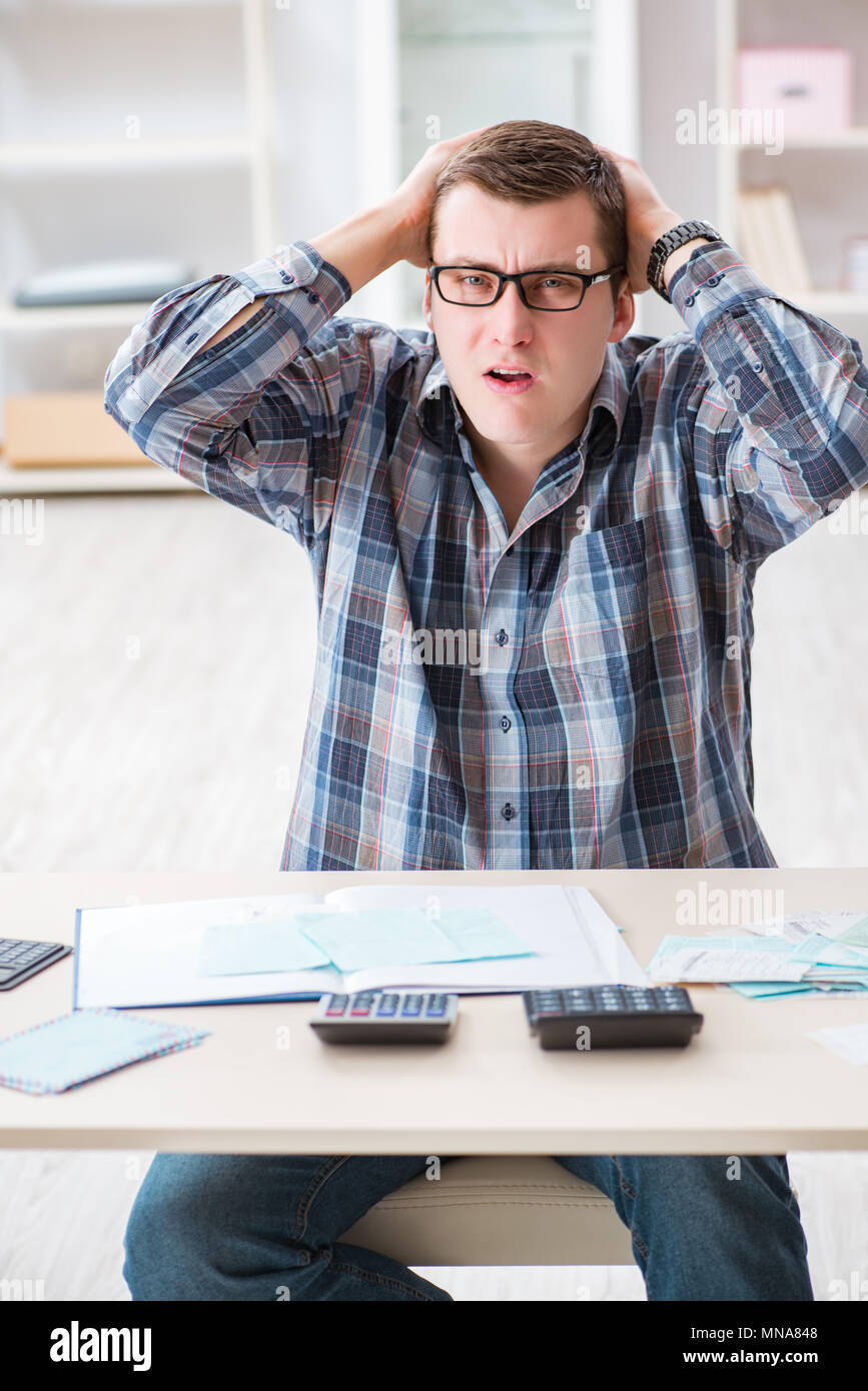 Young man frustrated at his house and tax bills Stock Photo - Alamy
