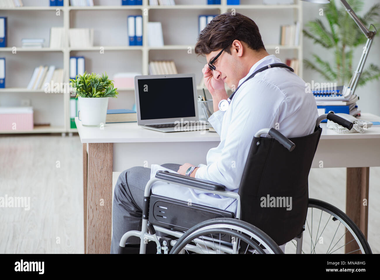 Disabled doctor on wheelchair working in hospital Stock Photo - Alamy
