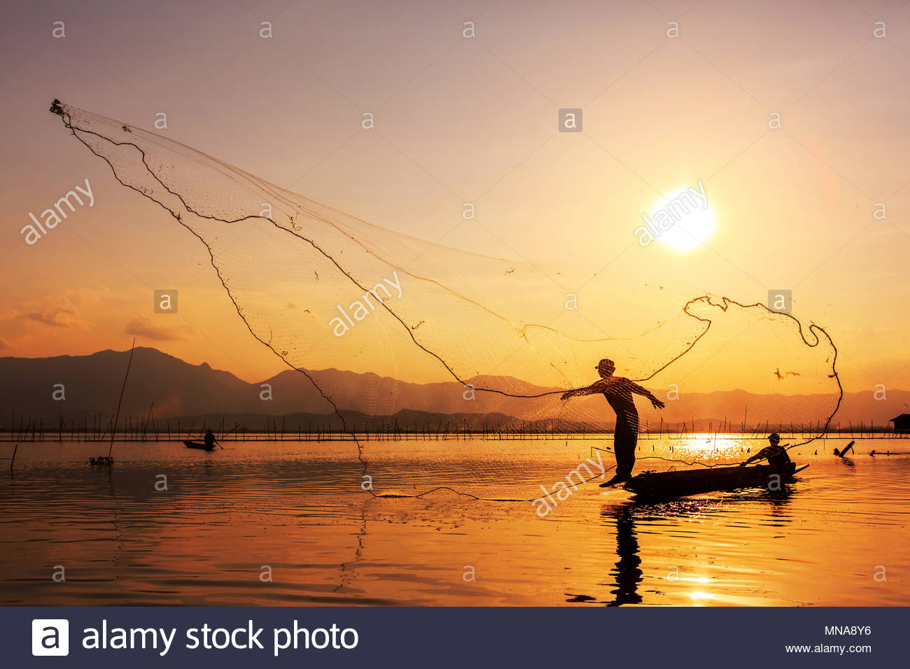 Man Throwing Fishing Net Into Water Stock Photos & Man Throwing Fishing ...