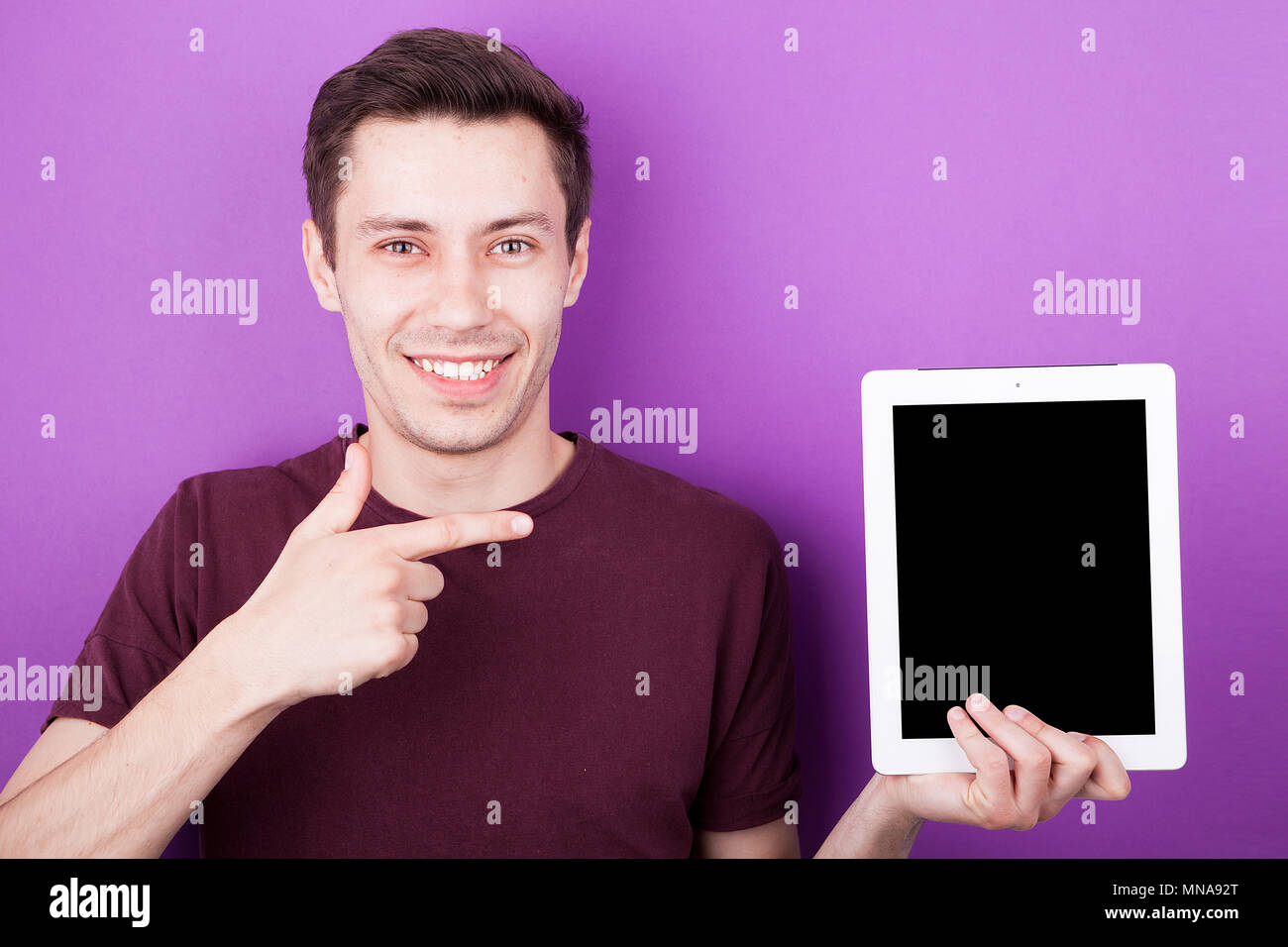 Successful young man pointing to a digital tablet Stock Photo - Alamy
