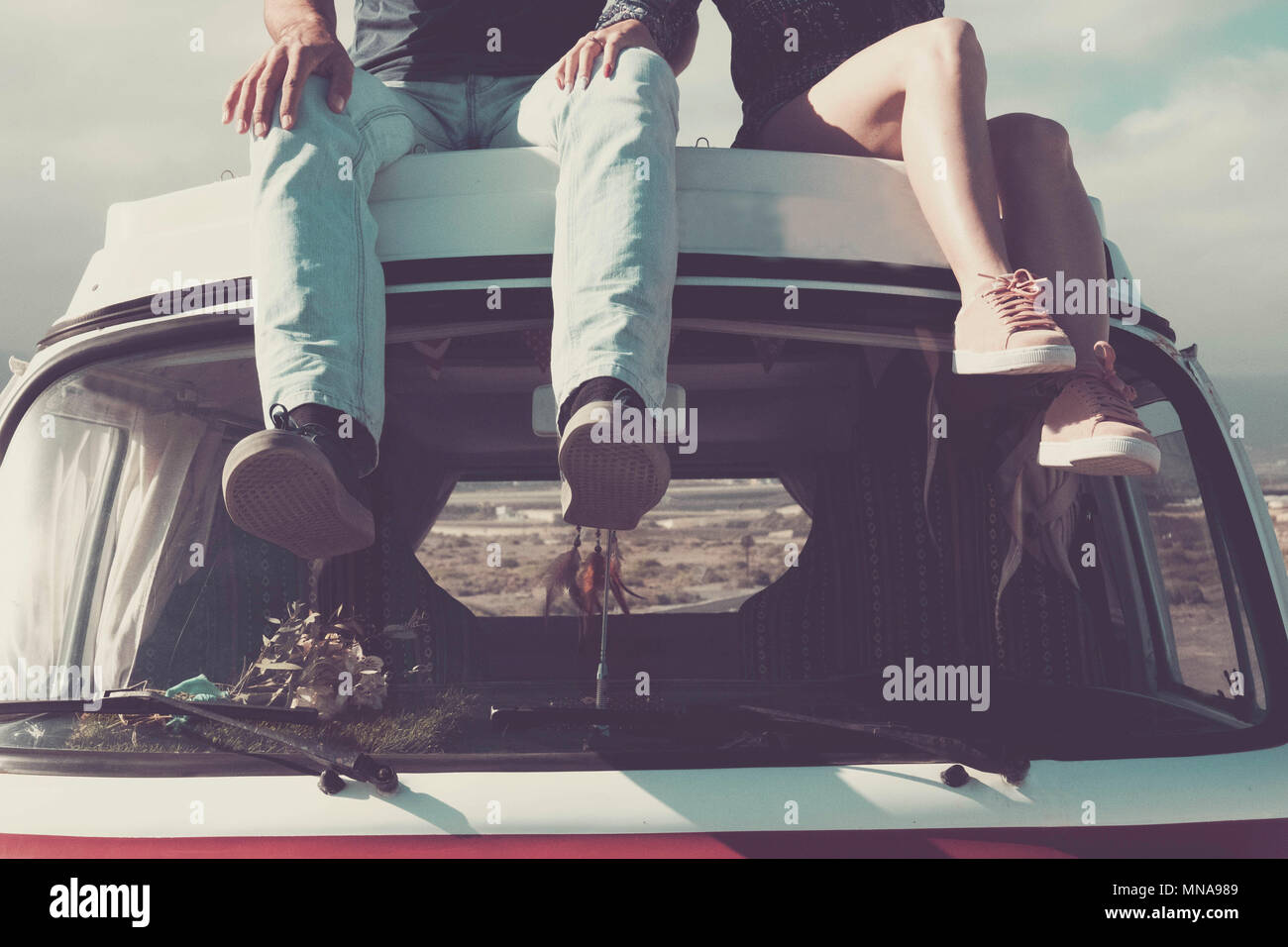 enjoy the vanlife. two pair of young legs sitted on the top of a ...