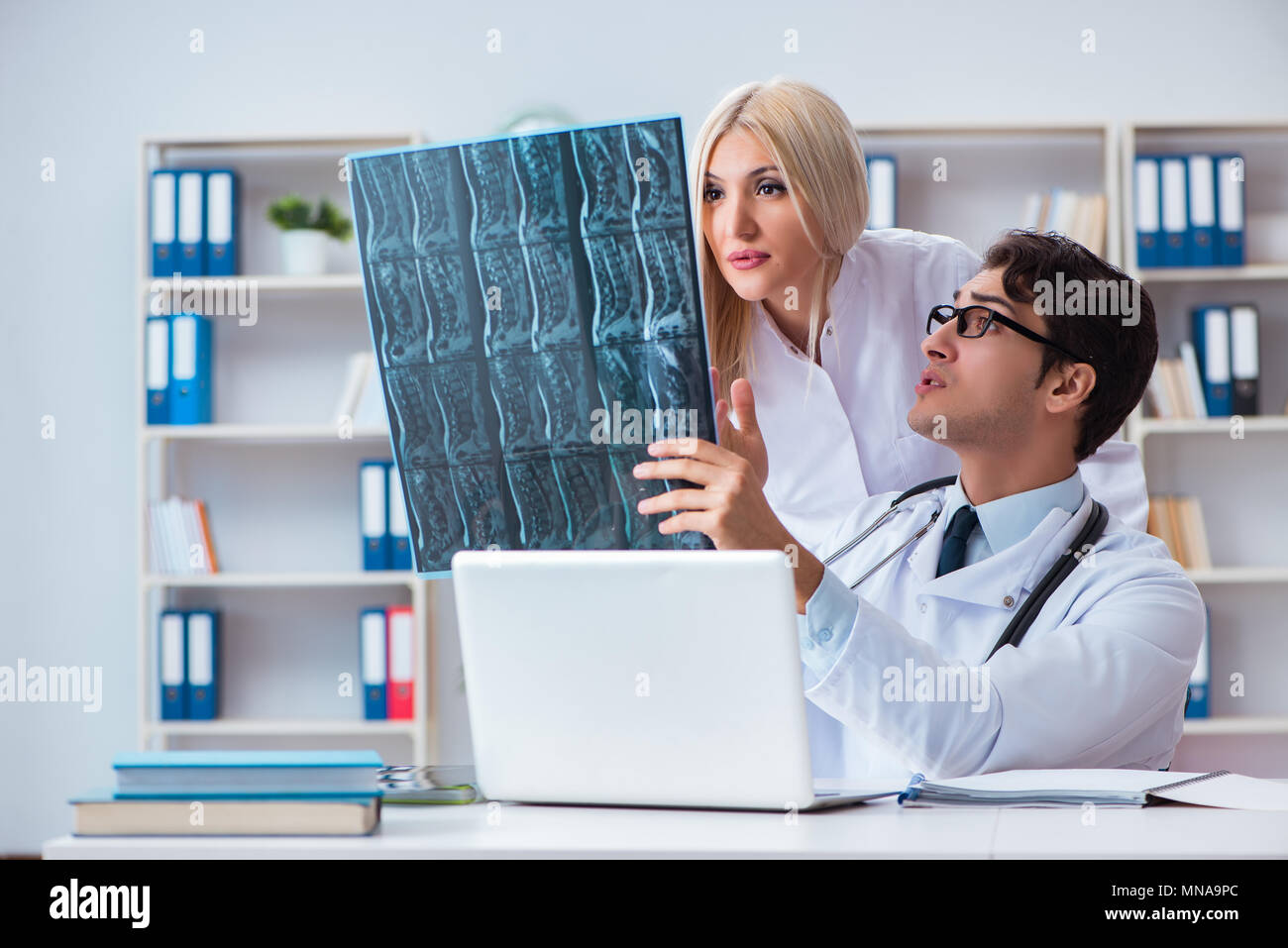 Two doctors examining x-ray images of patient for diagnosis Stock Photo ...