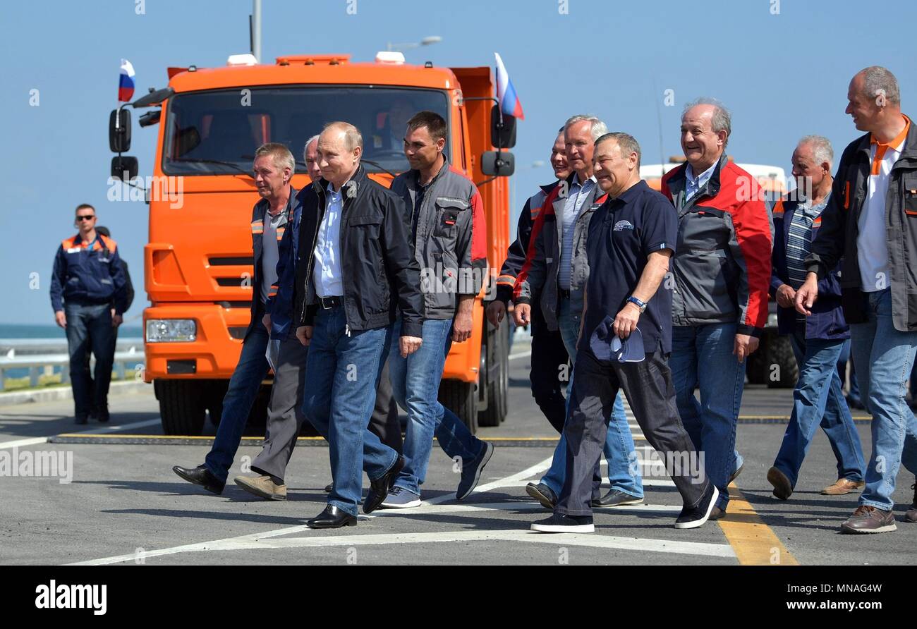 Russian President Vladimir Putin walks with construction workers and ...