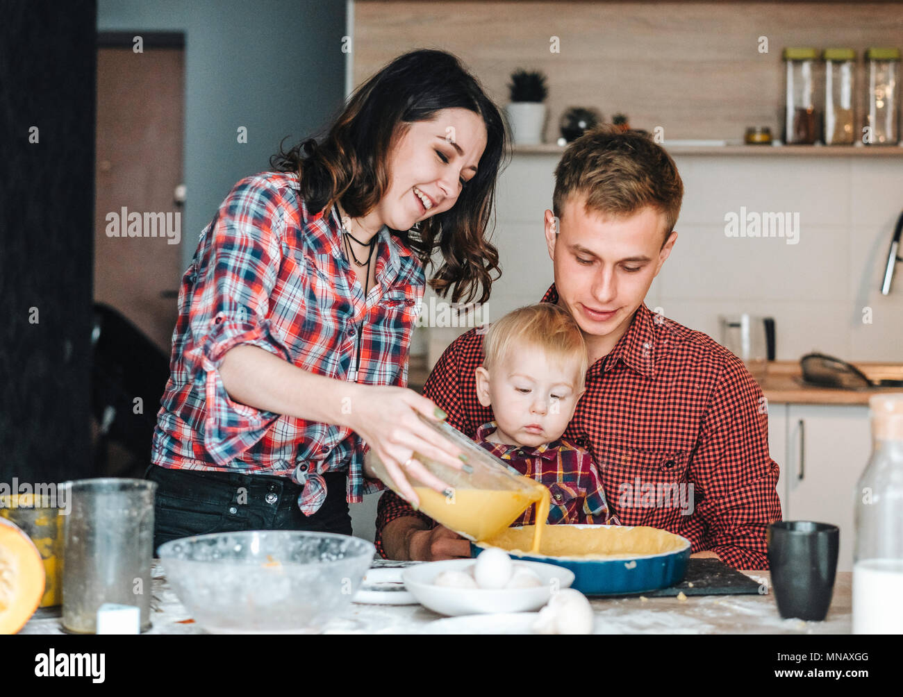 Dad, mom and little son cook a pie Stock Photo - Alamy