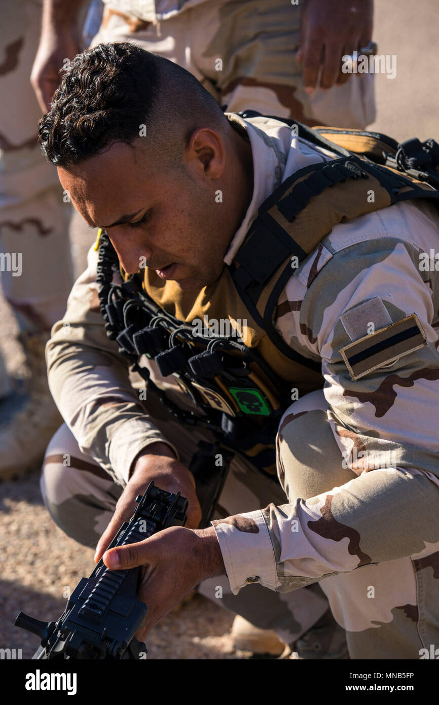 An Iraqi soldier, with the 74th Brigade, disassembles an M249 light ...