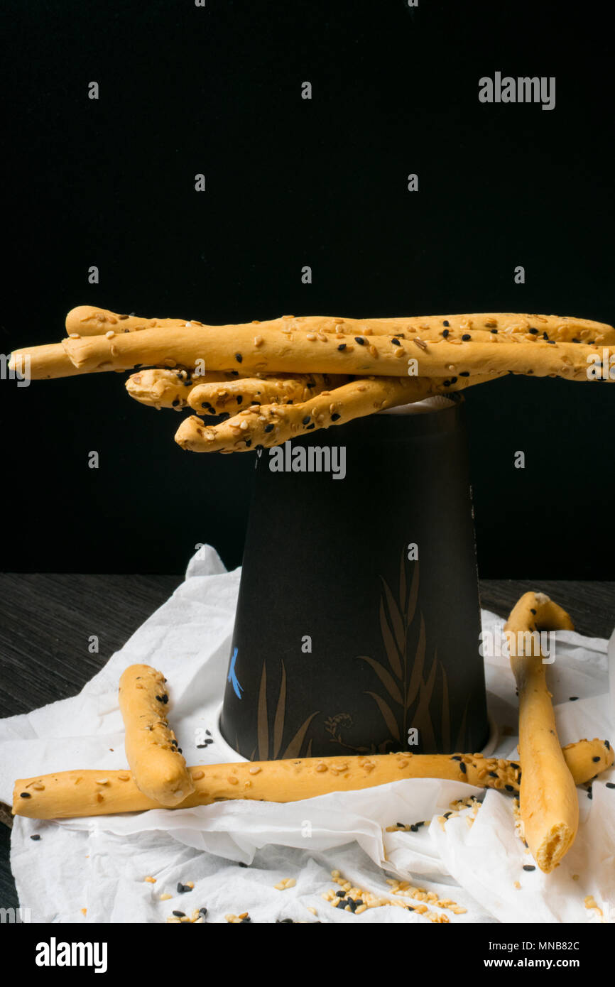 homemade snack, baked sticks with sesame and black cumin on the paper ...