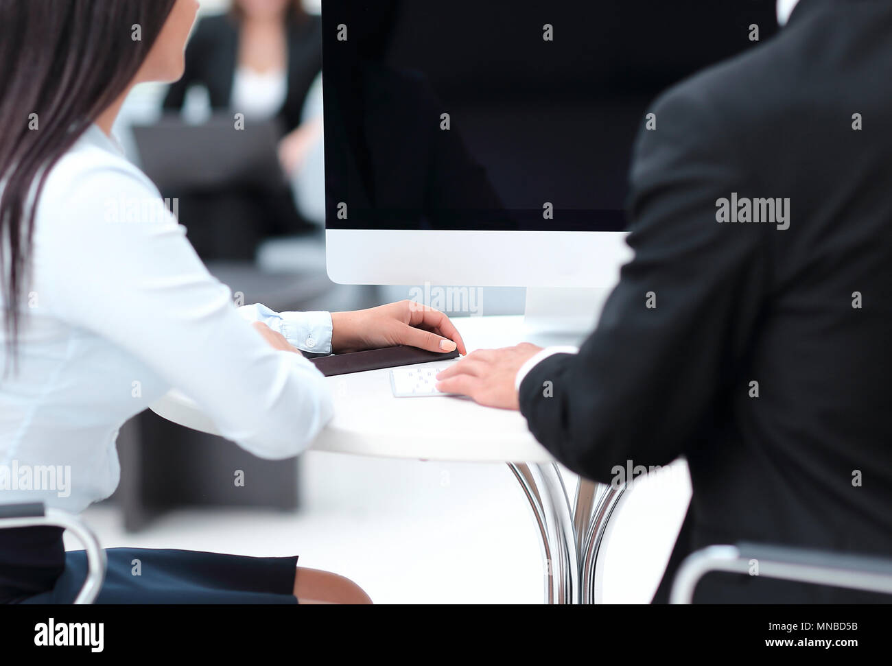 rear view.two successful employee sitting behind a Desk Stock Photo - Alamy