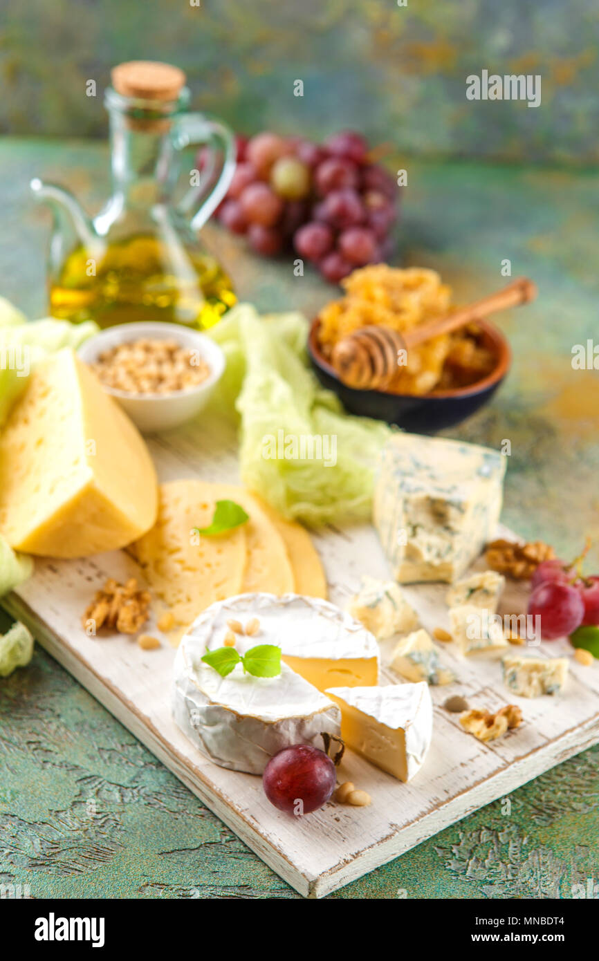 Different types of cheese, red grapes, honeycomb and nuts on a white ...