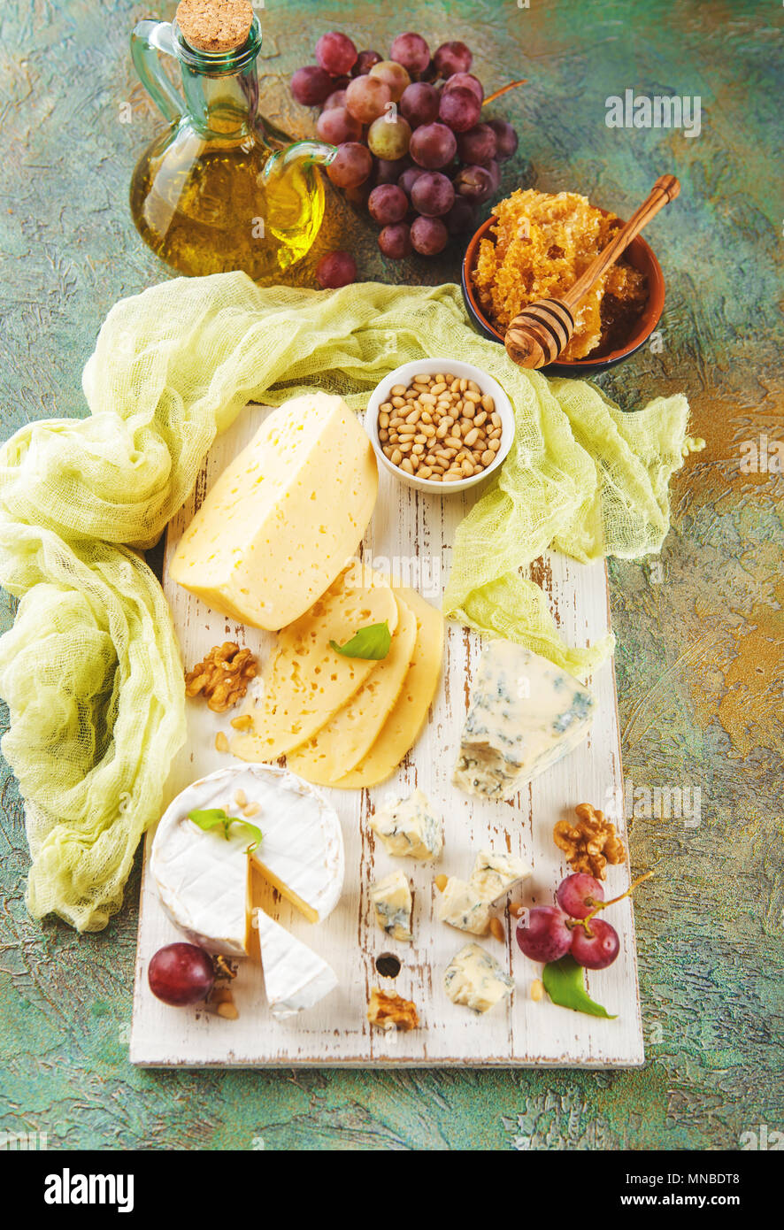 Different types of cheese, red grapes, honeycomb and nuts on a white ...
