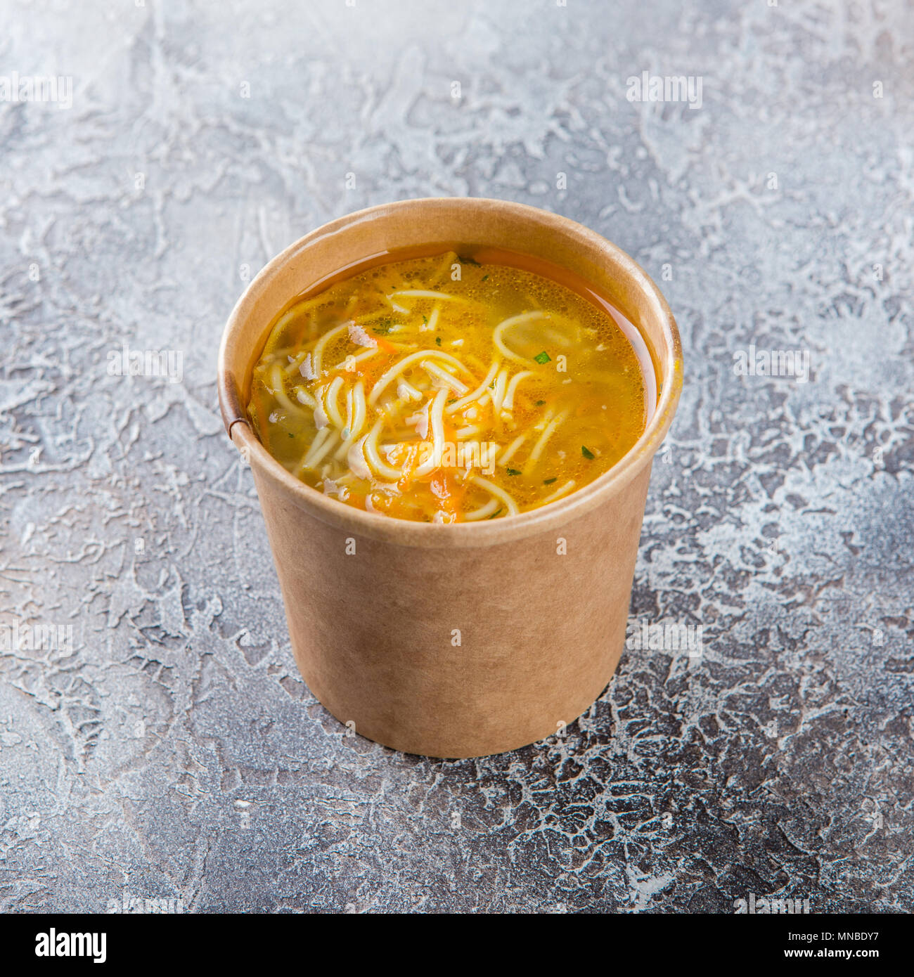 Chicken soup with noodles in a paper cup. Food delivery Stock Photo - Alamy