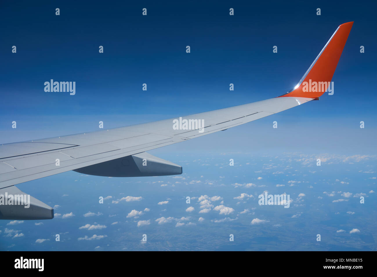 Red and white wing of the aircraft on blue sky background Stock Photo ...