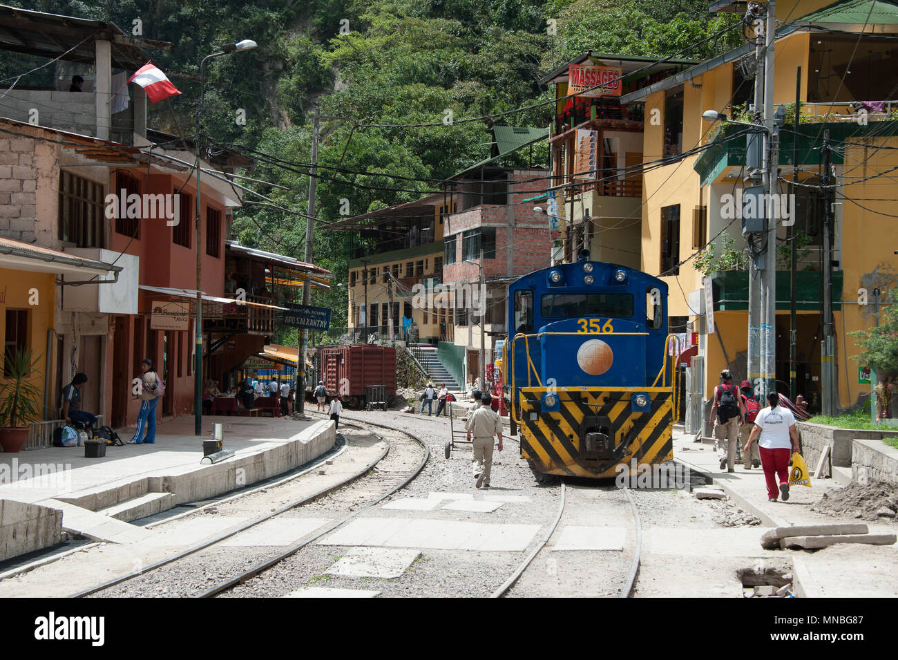 A peru rail train passes by the mountainous town of Aguas Calientes in ...