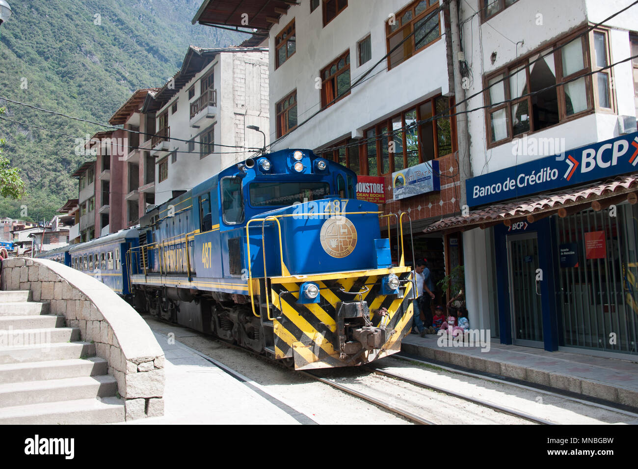 A peru rail passenger train passes by the town of Aguas Calientes in ...
