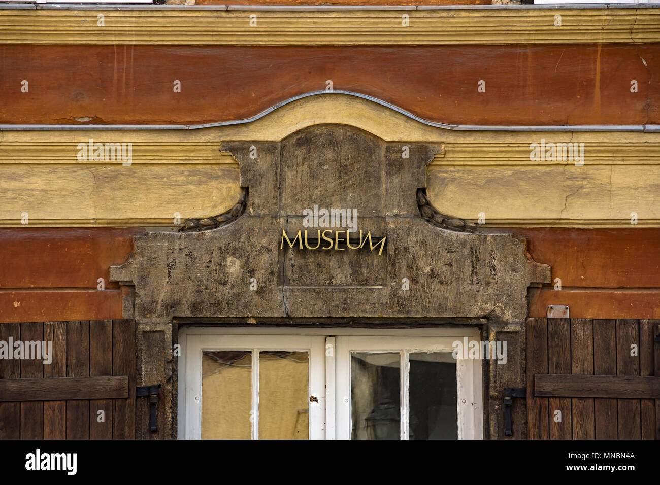 Weathered golden metal lettering on sign for a museum with a lopsided M ...