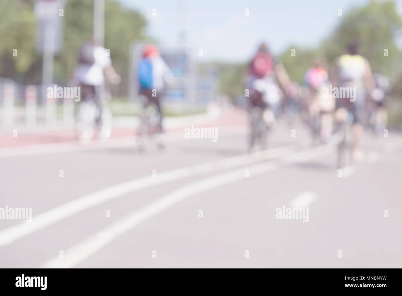 Group of cyclist cycling back to us on the road in the countryside ...