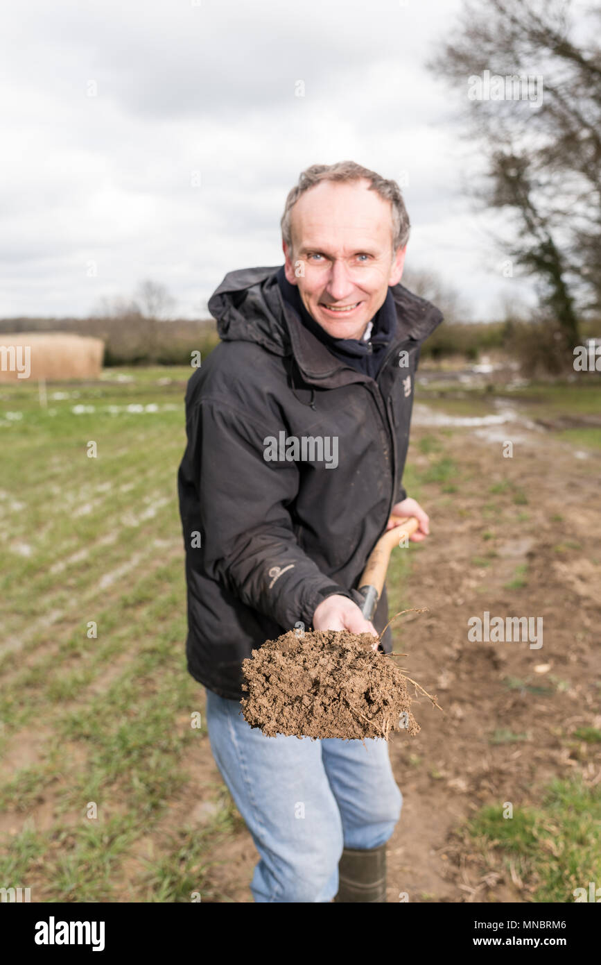 A man digging soil on a farm Stock Photo - Alamy