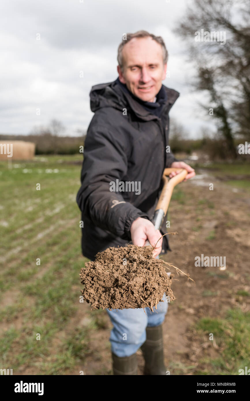 A man digging soil on a farm Stock Photo - Alamy