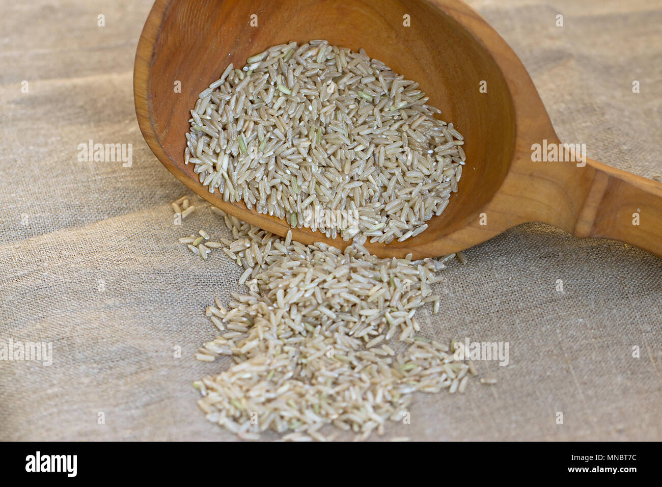 Raw brown rice and wooden spoon Stock Photo - Alamy